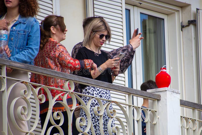 Group on Balcony, Woman in Sunglasses Using Phone, Patterned Outfits ...