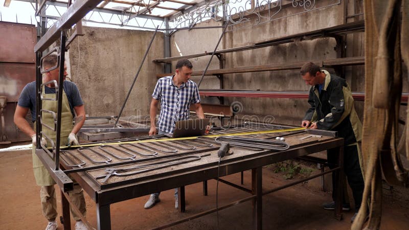 A Group of Blacksmiths Works in a Forge, they Weld Rods with a Welding ...
