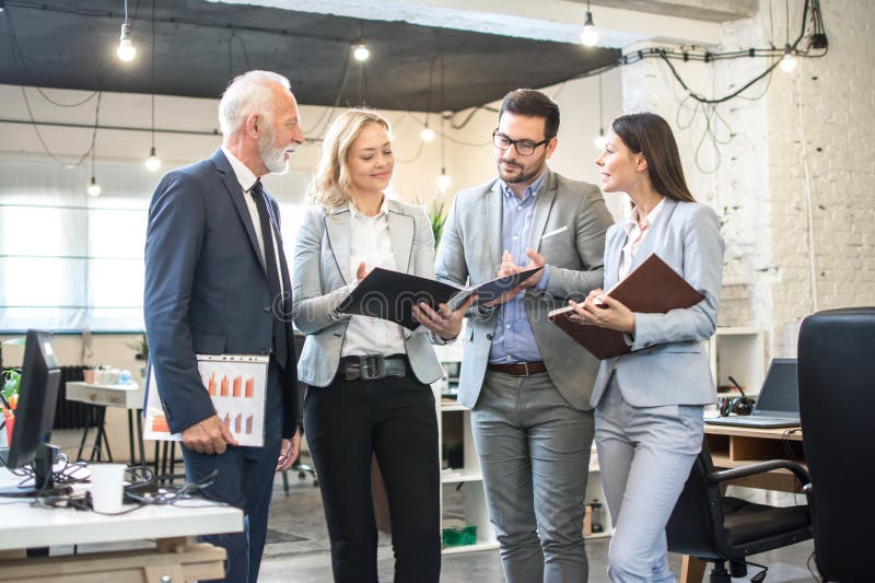 Group of Business People Discussing Document during Meeting in Office ...