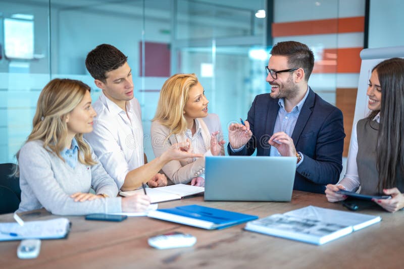 Group of Business People Gathered Together at a Table Working on ...