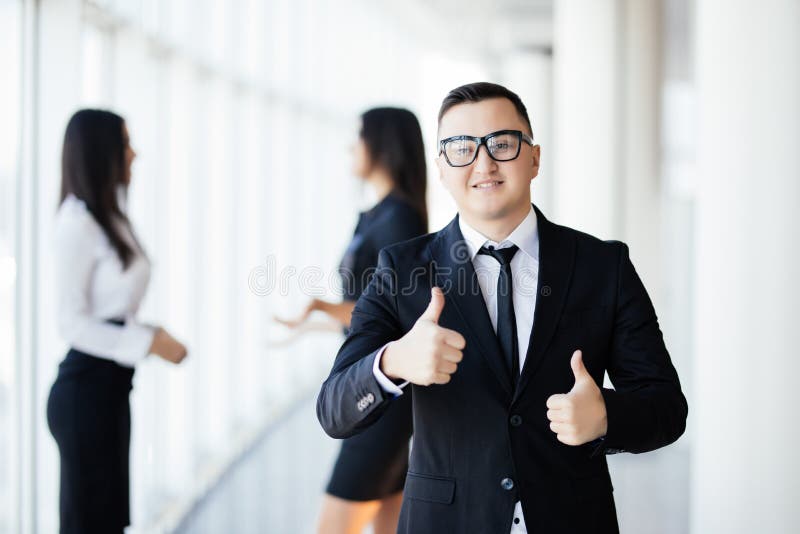 Group of Business People with Leader with Thumbs Up at Front in Office ...