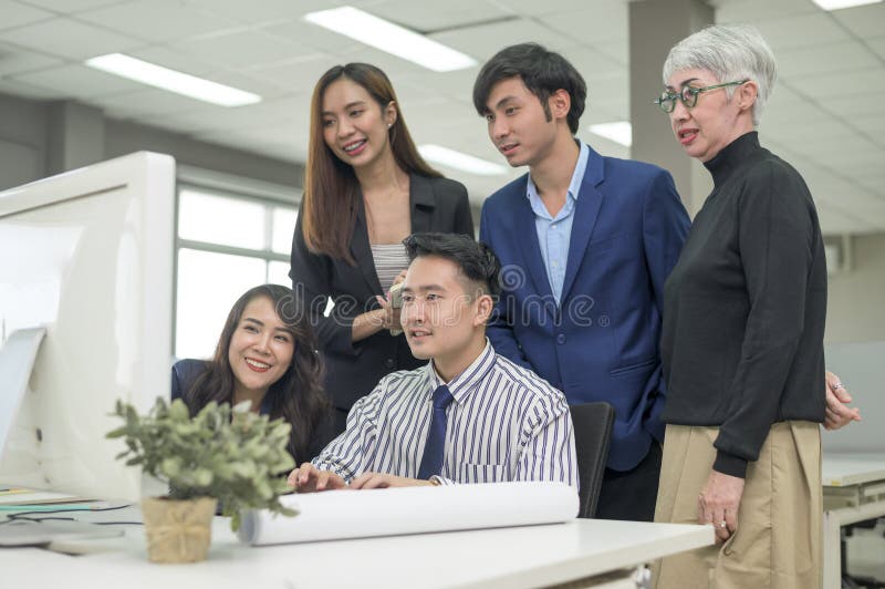 Group of Business People Looking at Computer and Discussing in Modern ...