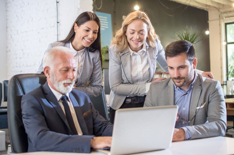 Group of Business People Looking at Laptop, Talking at Meeting Table in ...