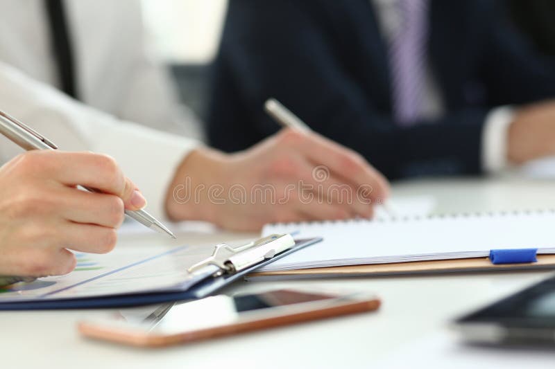 Group of Business People Sitting at Table with Tablets and Pens Taking ...