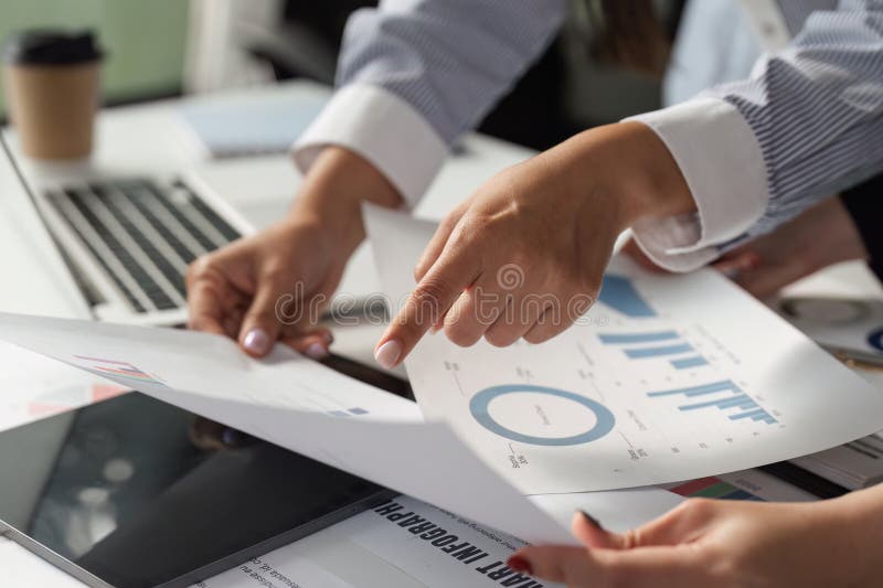 Business Professionals Reviewing Financial Documents and Charts in a ...