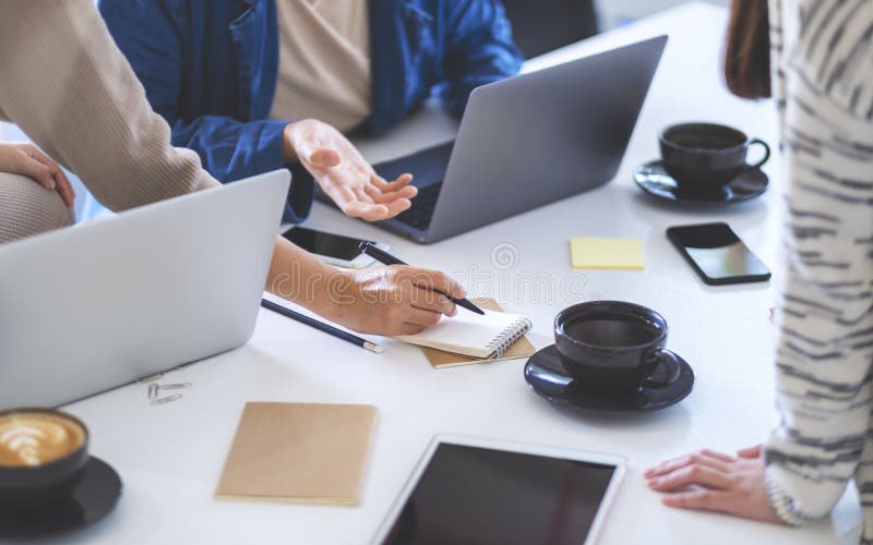 Businessman Discussing and Writing on Notebook with Laptop Computer on ...