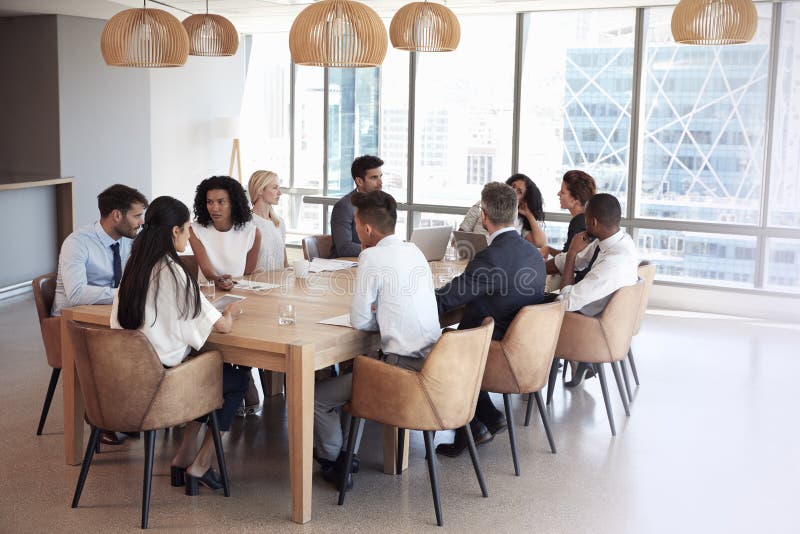 Group of Businesspeople Sitting Around Table in Meeting Room Stock ...