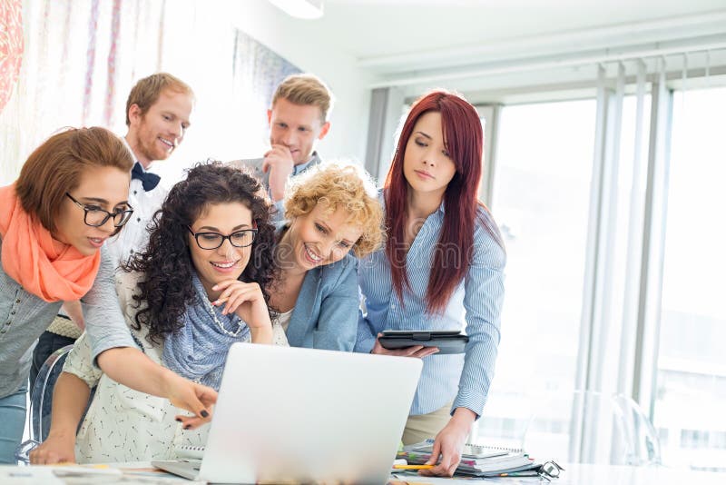 Group of Businesspeople Using Laptop at Desk in Creative Office Stock ...