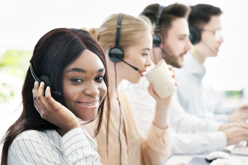Group of Call Centre Representatives with Headsets Working on Computers ...