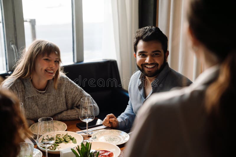 Group of Cheerful Friends Talking while Dining in Restaurant Stock ...