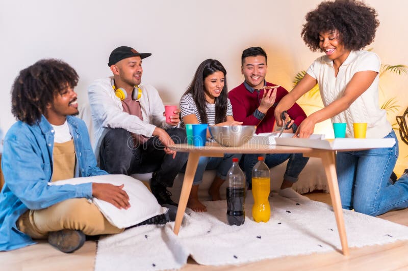 Group of Cheerful Multiethnic Friends on a Sofa Eating Pizza at a Home ... Group of Cheerful Multiethnic Friends on a Sofa Eating Pizza at a Home ...