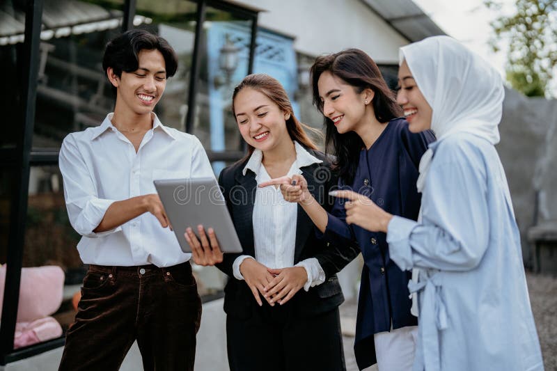 Group of Cheerful Young Businesspeople Using a Tablet at an Outdoor ...