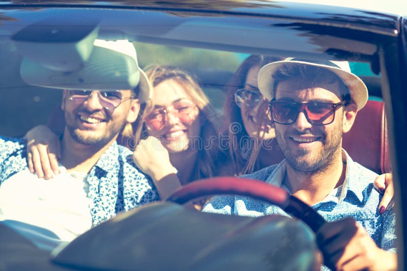Group of Cheerful Young Friends Driving Car and Smiling in Summer Stock ...