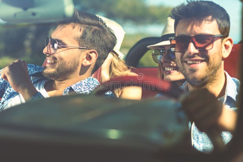 Group of Cheerful Young Friends Driving Car and Smiling in Summer Stock ...
