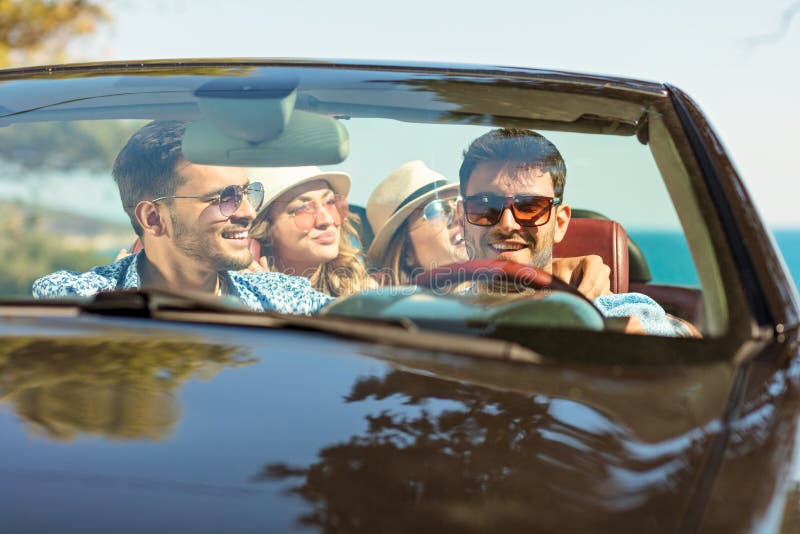 Group of Cheerful Young Friends Driving Car and Smiling in Summer Stock ...