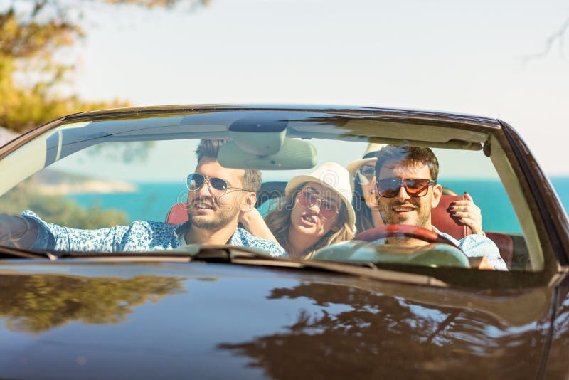 Group of Cheerful Young Friends Driving Car and Smiling in Summer Stock ...