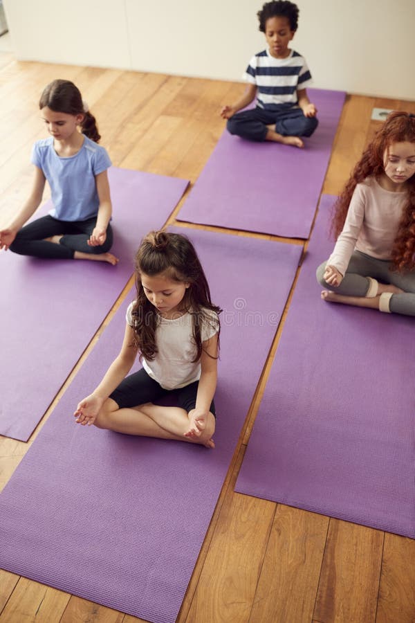 Group of Children Sitting on Exercise Mats and Meditating in Yoga ...