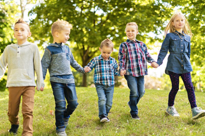 A Group of Children in Spring Field Having Fun Stock Photo - Image of ...