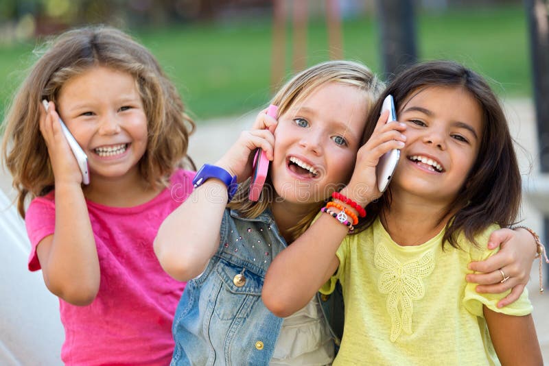 Group of Childrens Using Mobile Phones in the Park. Stock Photo - Image ...