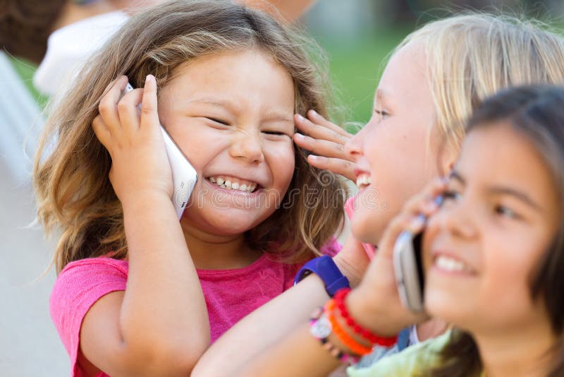 Group of Childrens Using Mobile Phones in the Park. Stock Photo - Image ...