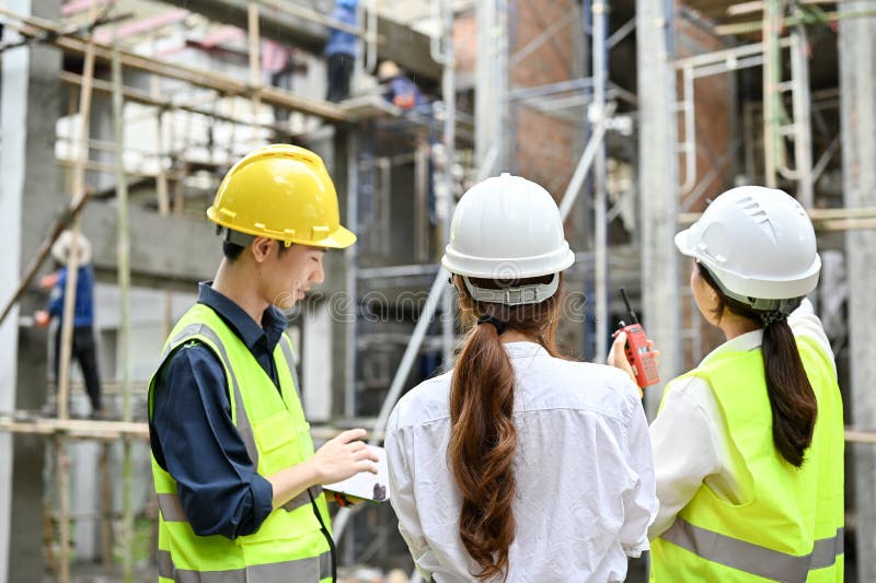 A Group of Civil Engineer Talking about Their Plan in Front of the ...