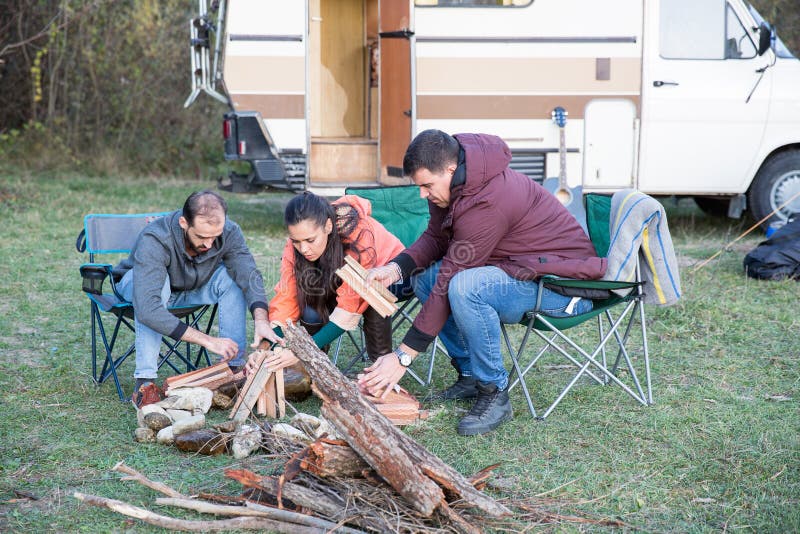 Group of close friends setting up the camp fire. - Stock Image - Everypixel