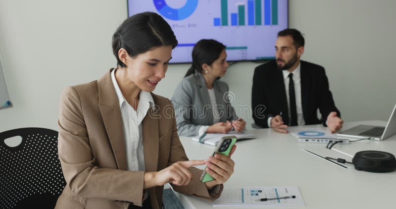 Group of Colleagues Engaged in Different Tasks Around Conference Table ...
