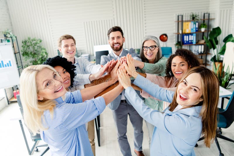 Group of Colleagues in Formalwear Joining Hands in a Gesture of ...