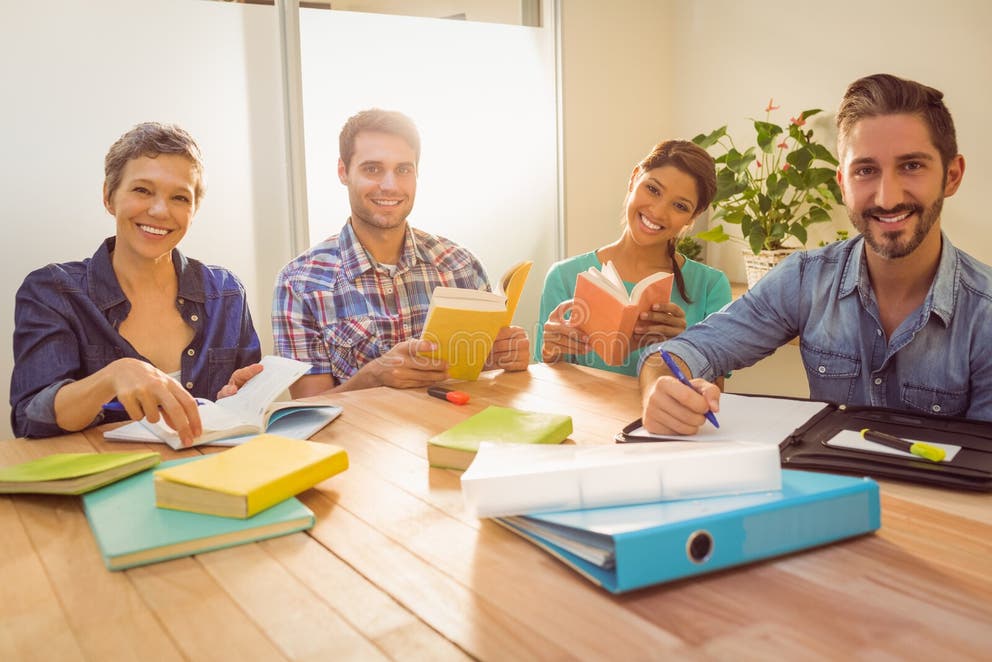 Group of Colleagues Reading Books and Smiling at Camera Stock Image ...