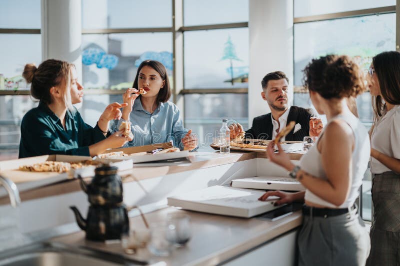 A Group of Colleagues Take a Break in the Office Kitchen, Enjoying ...