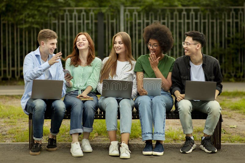 Group of College Students with Laptops and Tablet Pc Studying Outdoors ...