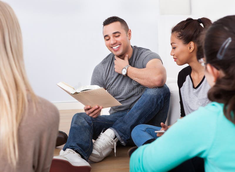 Group of College Students Reading Book on Floor in Classroom Stock ...