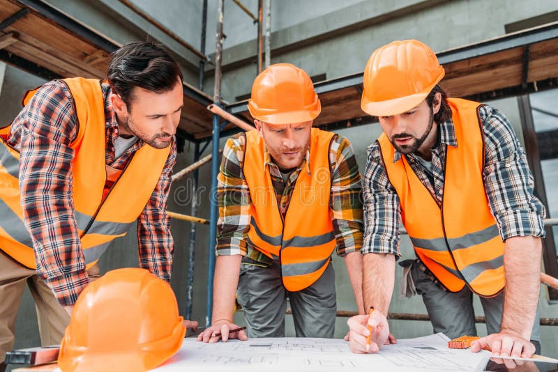 Group of Confident Builders Looking at Building Plan Stock Photo ...
