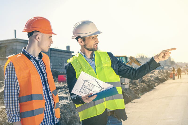 Group of Construction Engineers on a Building Plot. Real Estate Project ...