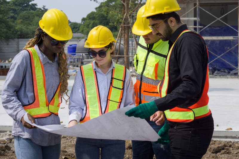 Group of Construction Workers Gathered at a Construction Site Reviewing ...