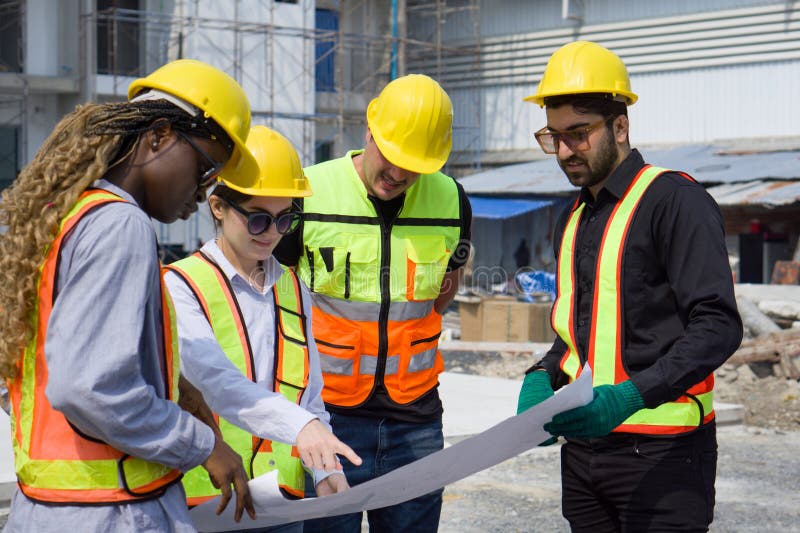 Group of Construction Workers Gathered at a Construction Site Reviewing ...