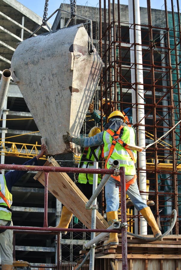 A Group of Construction Workers Pouring Concrete into Column Form Work ...