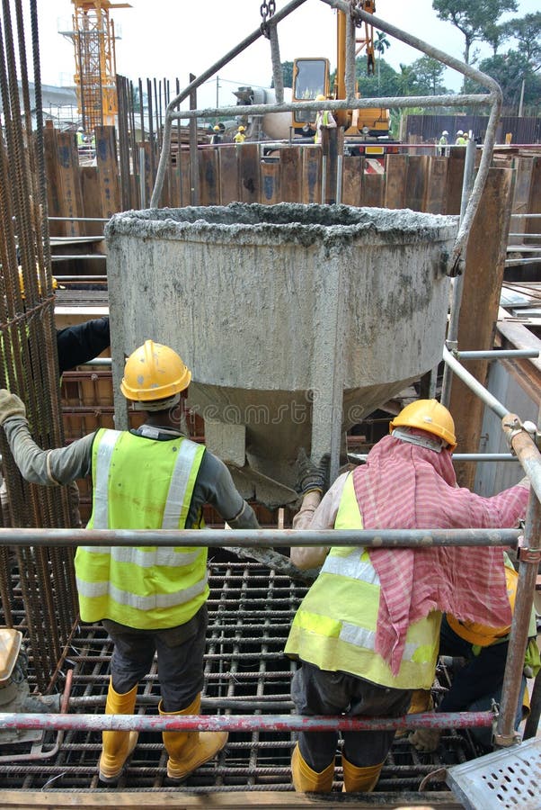A Group of Construction Workers Pouring Concrete into Pile Cap Formwork ...