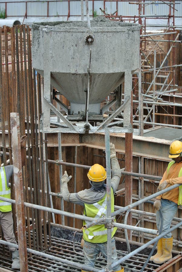 A Group of Construction Workers Pouring Concrete into Pile Cap Formwork ...