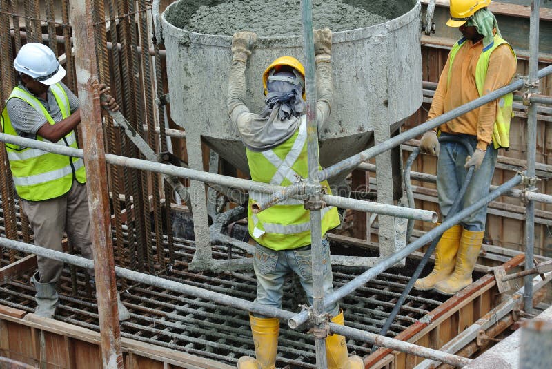 A Group of Construction Workers Pouring Concrete into Pile Cap Formwork ...