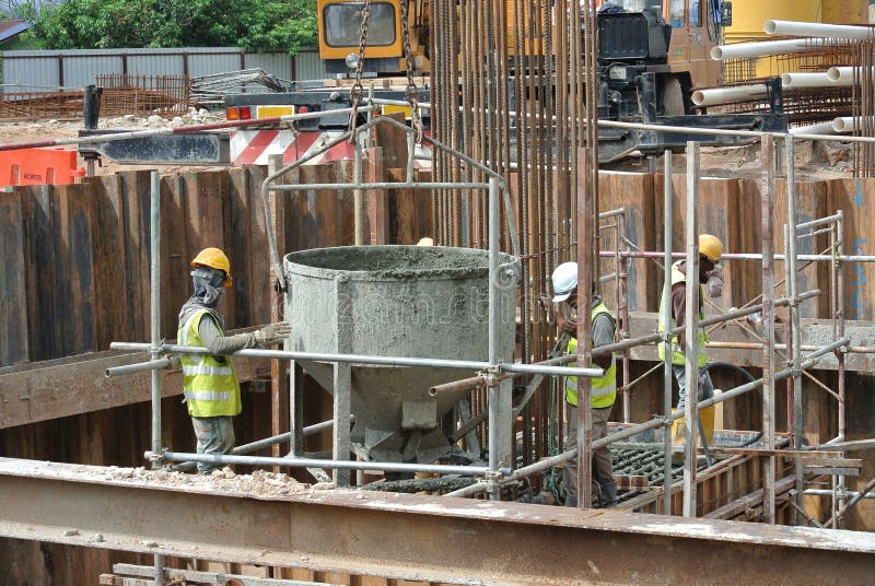 A Group of Construction Workers Pouring Concrete into Pile Cap Formwork ...