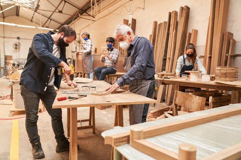 Group of Craftsmen with Face Mask in Workshop Stock Image - Image of ...