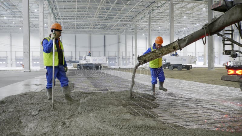 A Group of Dedicated Workers Expertly Pouring Concrete on an Industrial ...