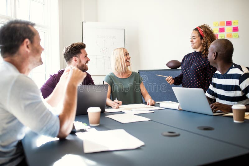 Group of Designers Smiling while Working Around an Office Table Stock ...