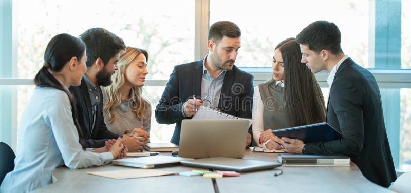 Group of Diverse Businesspeople Going Over Paperwork Together and ...