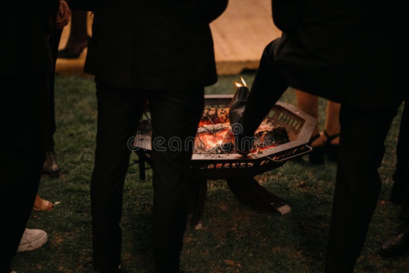 A Group of Diverse Individuals are Standing Together Around a Fire Pit ...