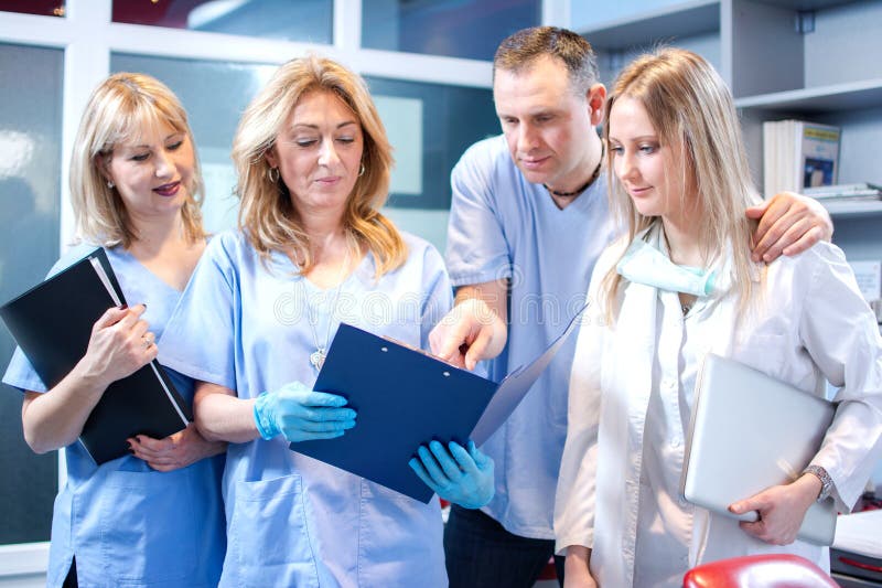 Group of Doctors Examining Medical Documents Together in Doctor S ...