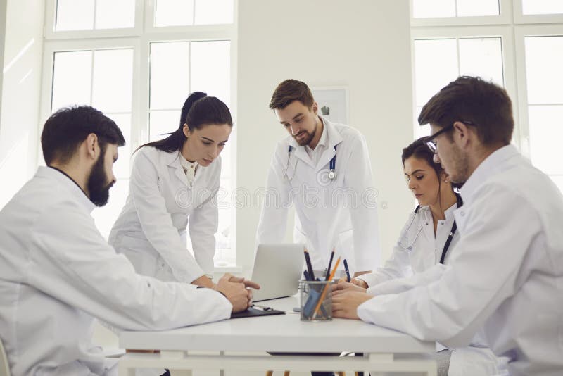 Group of Doctors Talking Sitting at a Table in the Office of the ...