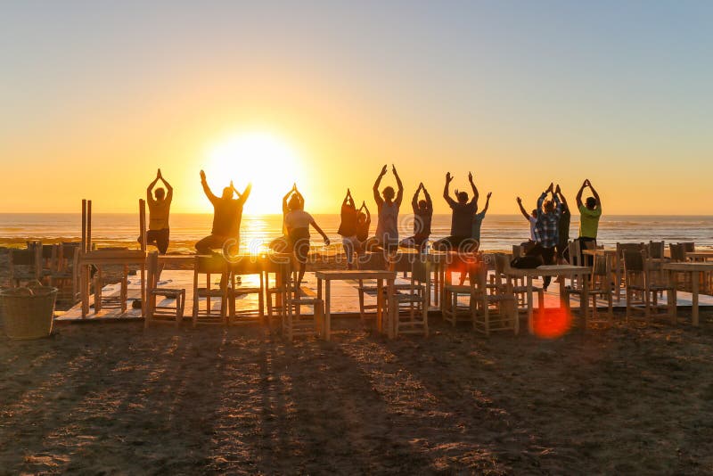 Group Doing Yoga Exercises the Beach at Sunset Stock Photo - Image of ...