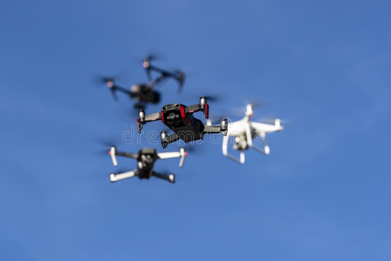 A Group of Drones Fly Together through the Air Against a Blue Sky Stock ...